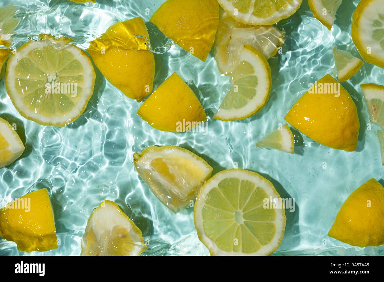 Refreshing turquoise citrus background with floating yellow lemon ...