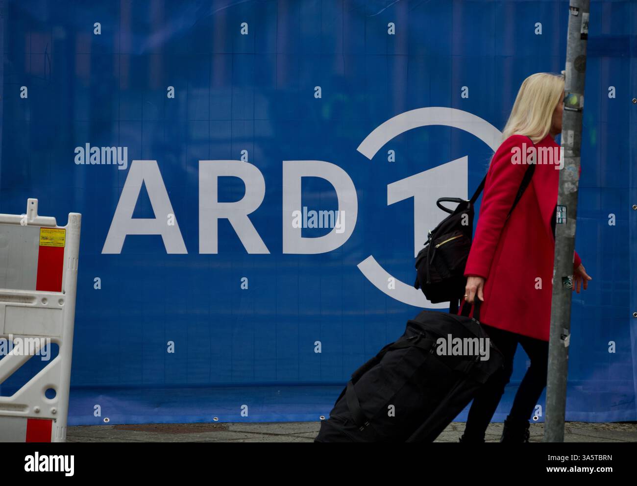 Berlin, Germany. February 23, 2025. A person walks by ARD banner Stock ...