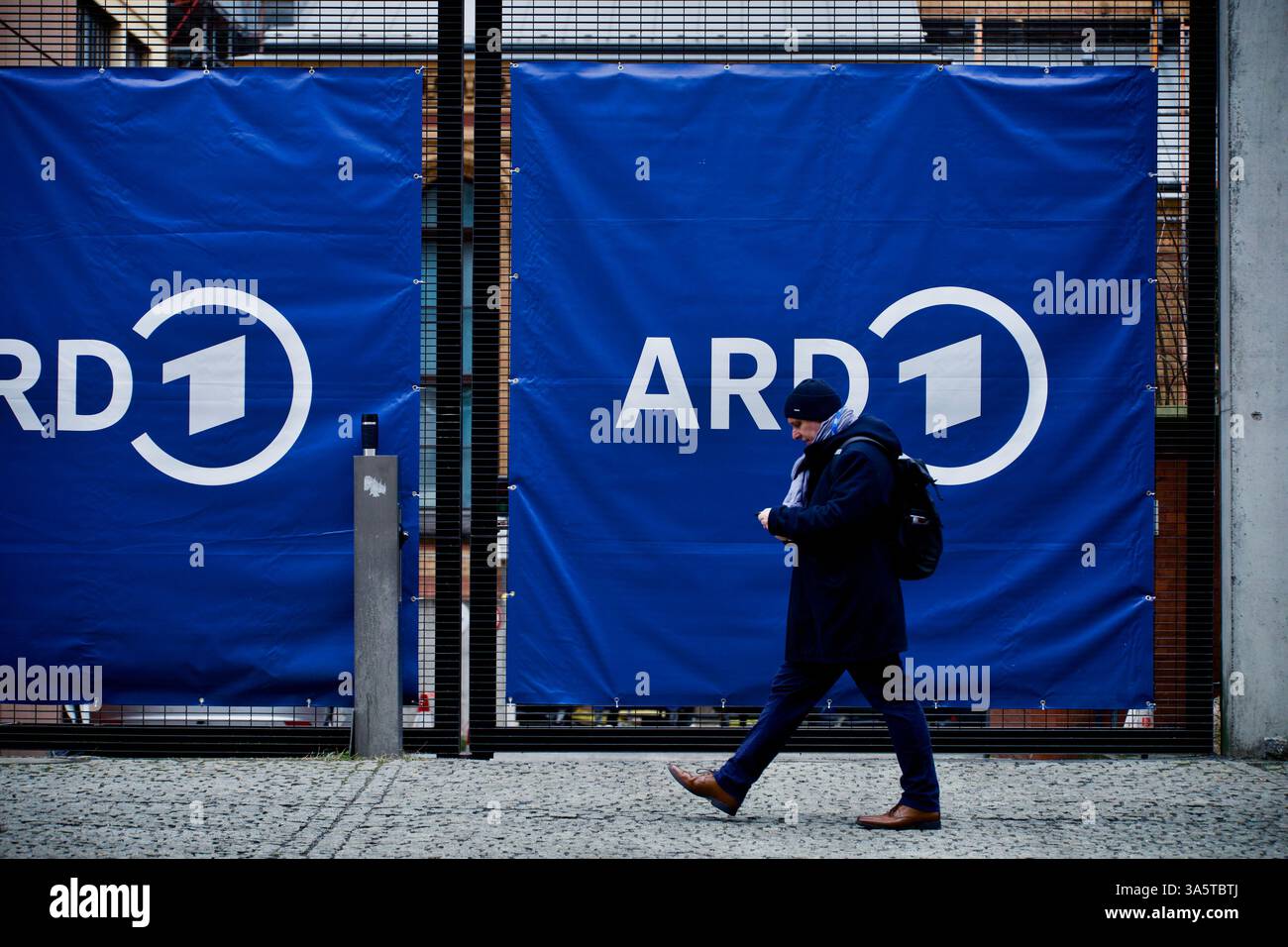 Berlin, Germany. February 23, 2025. A person walks by ARD banner Stock ...