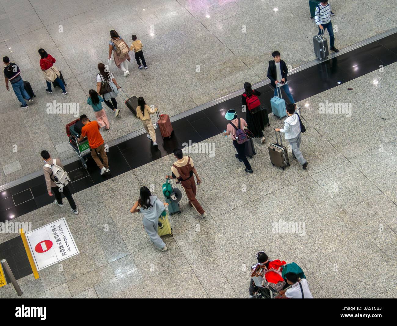 Hong Kong, China. 23rd Mar, 2025. Flight passengers are seen walking in the arrivals hall at ...