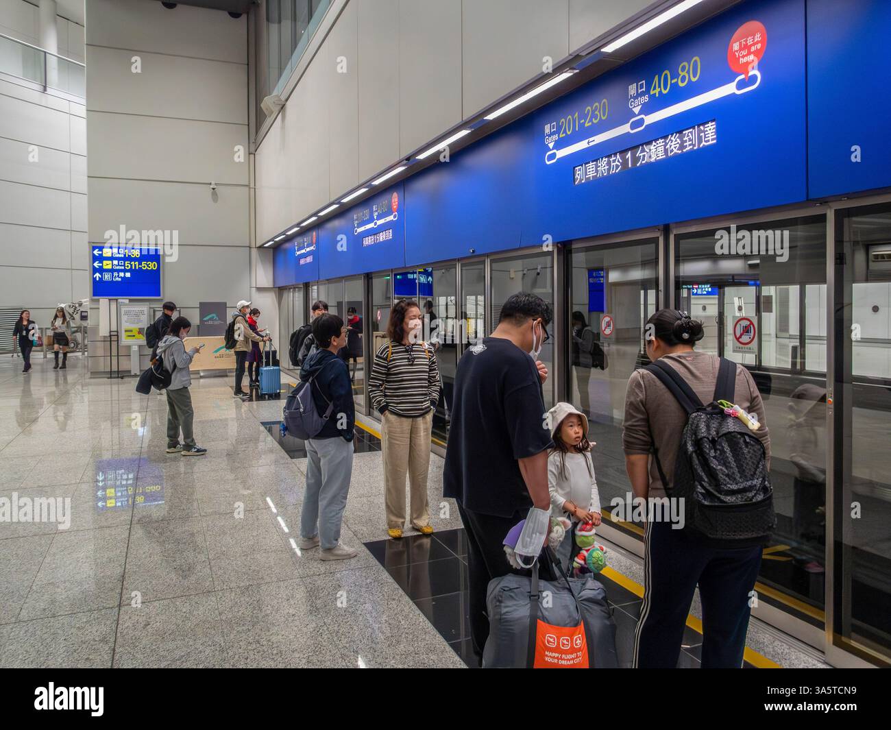 Hong Kong, China. 23rd Mar, 2025. Passengers are seen waiting to board the train in the ...