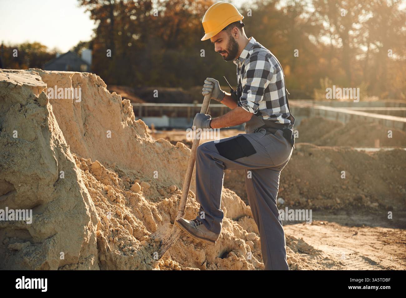 Soil, digging with a shovel. Worker is on the construction site at ...