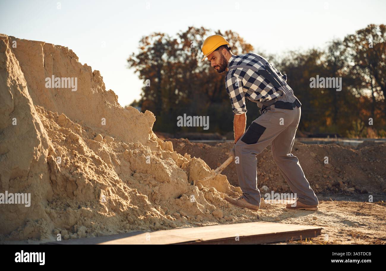 The soil, digging with shovel. Worker is on the construction site at ...