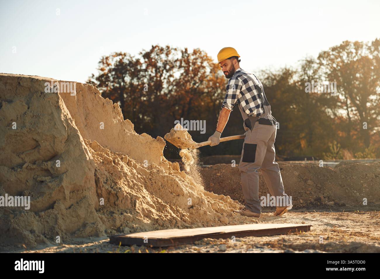 The soil, digging with shovel. Worker is on the construction site at ...