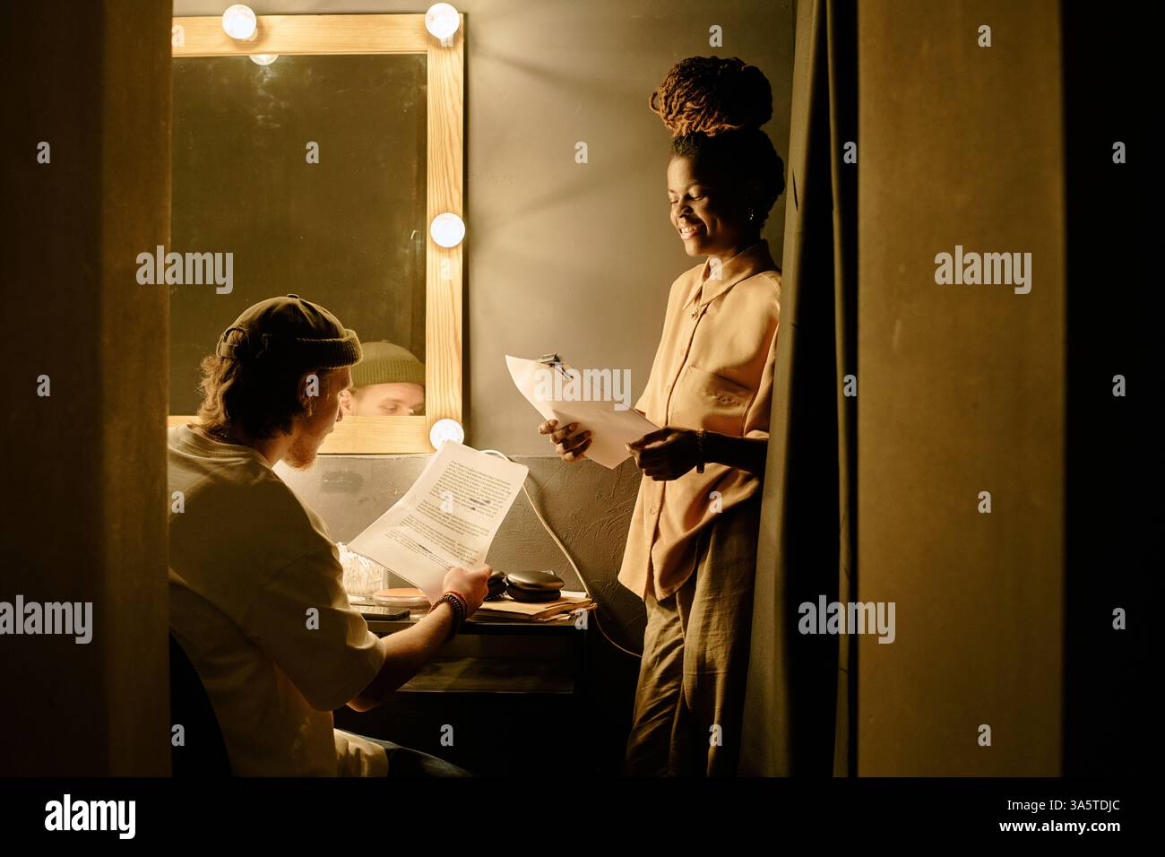 Two people in dressing room collaborating on theater script. One person ...