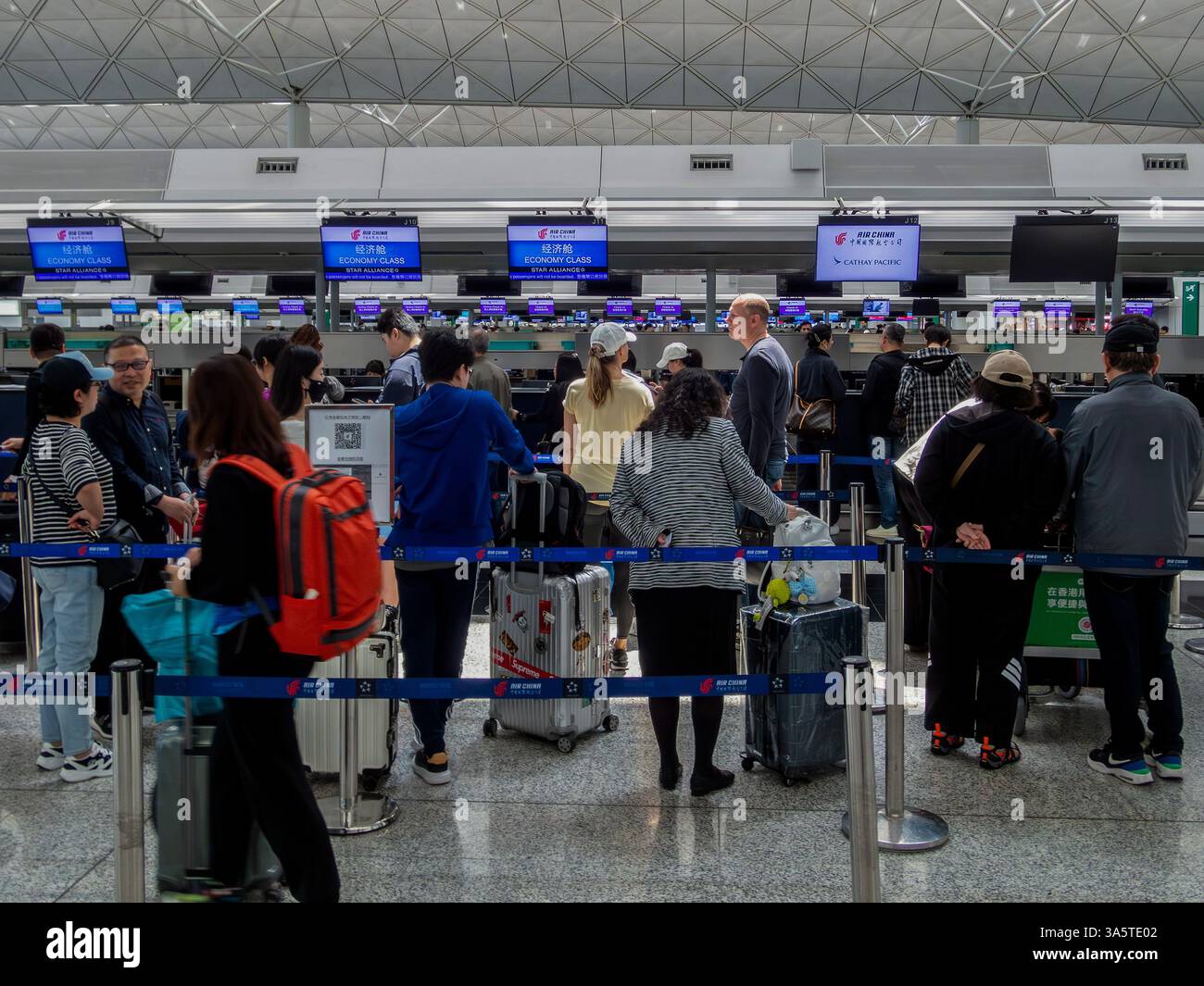 Passengers are seen waiting to check in at the counter in the departure hall at Hong Kong ...