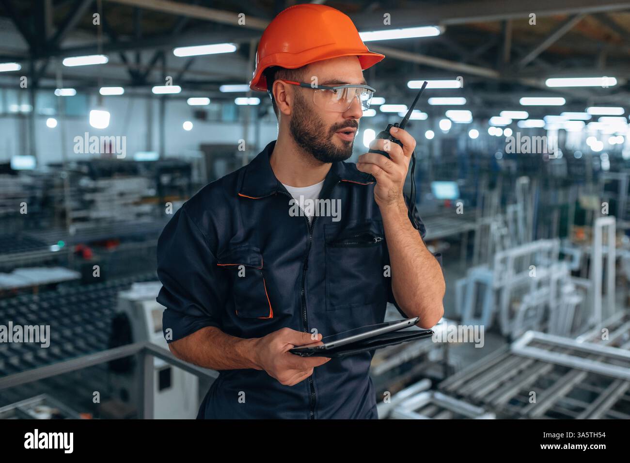 Giving instructions, using radio, walkie talkie. Man is working in the ...