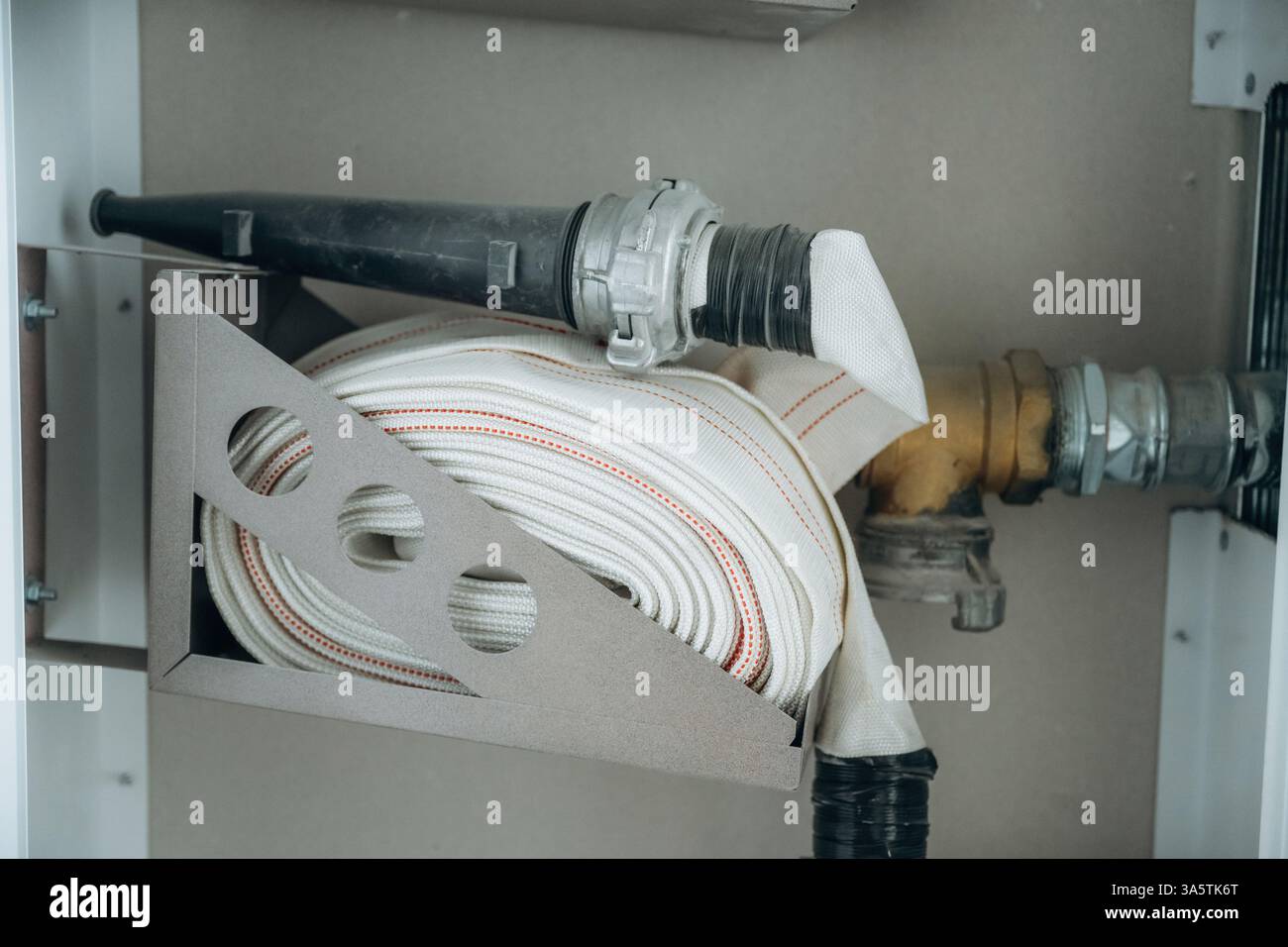 Fire hose is against the wall, ready to use Stock Photo - Alamy