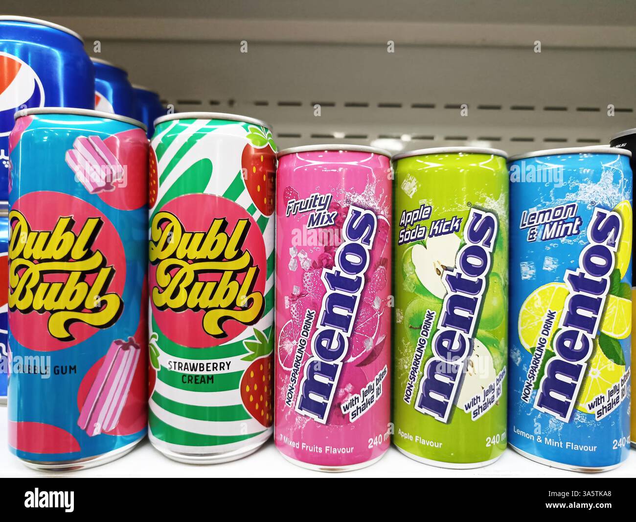 Colorful beverage cans on store shelf displaying various flavors and ...