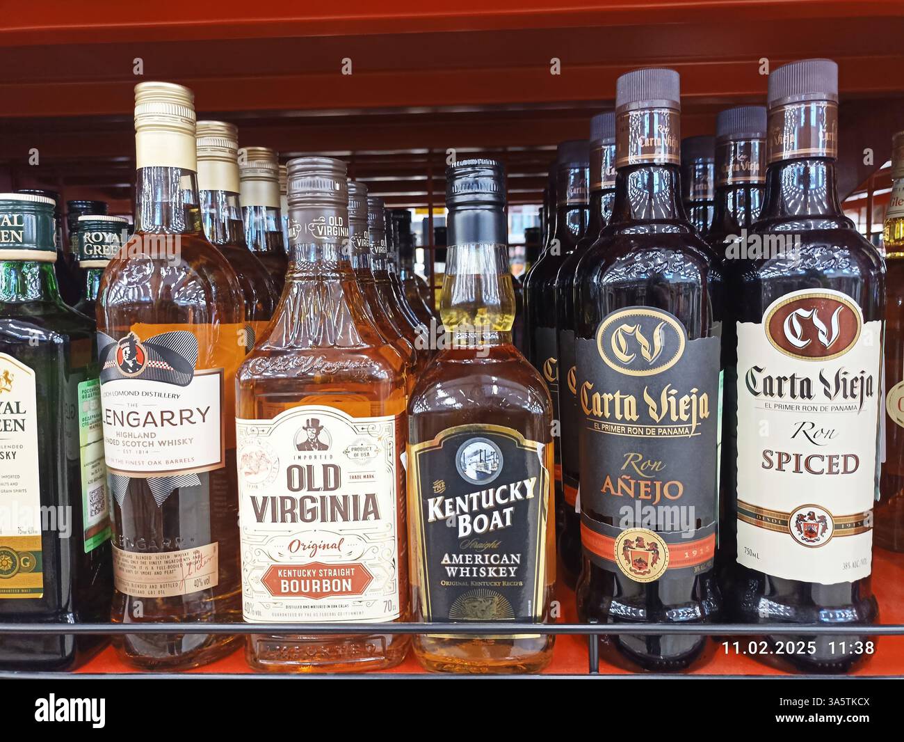 Assorted whiskey and rum bottles on store shelf display Stock Photo - Alamy