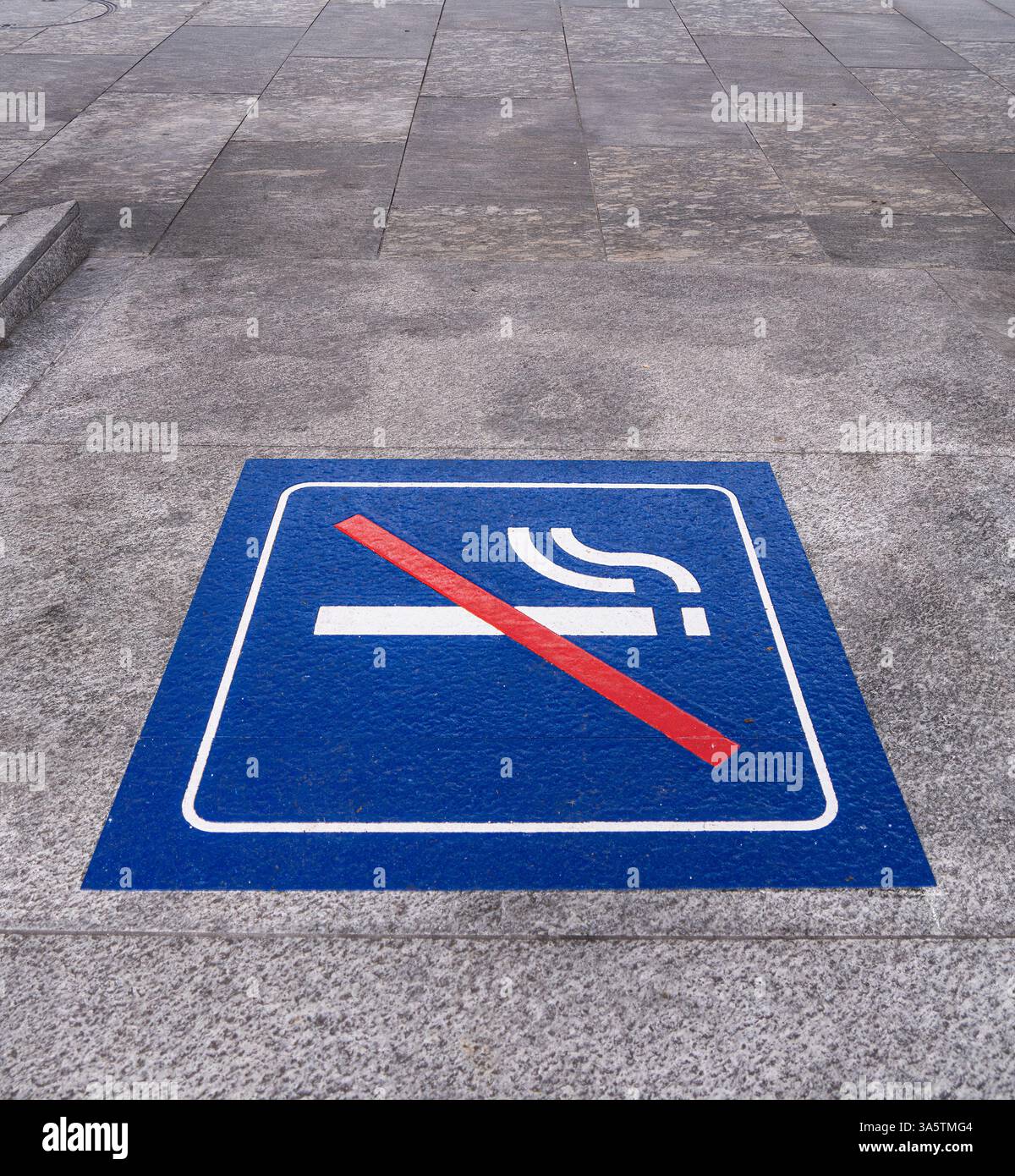 A no smoking sign painted on a concrete surface, featuring a cigarette ...