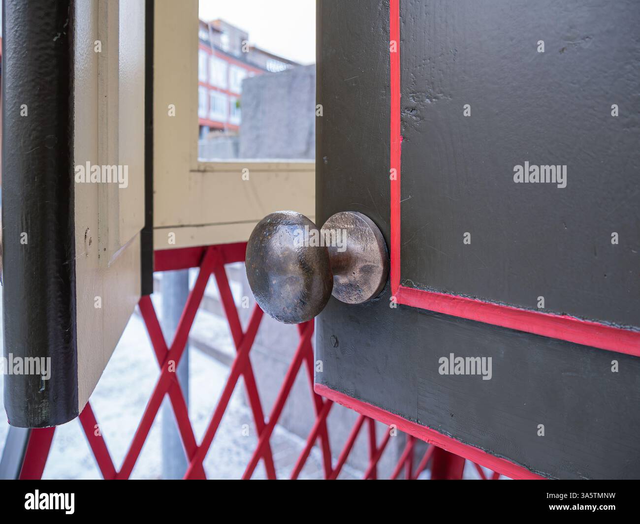 A close-up view of a door knob on a partially open door of the old ...