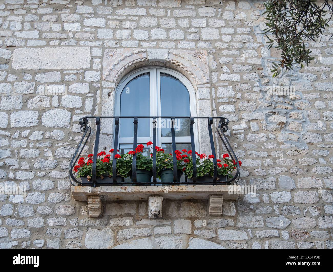 A charming balcony adorned with vibrant red geraniums, set against a ...