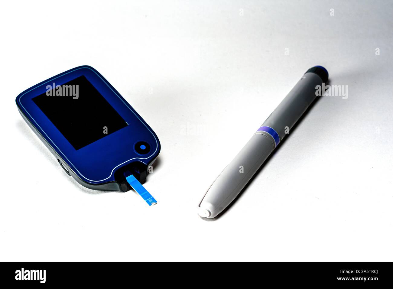 Glucose meter and insulin pen showing diabetes management tools Stock ...
