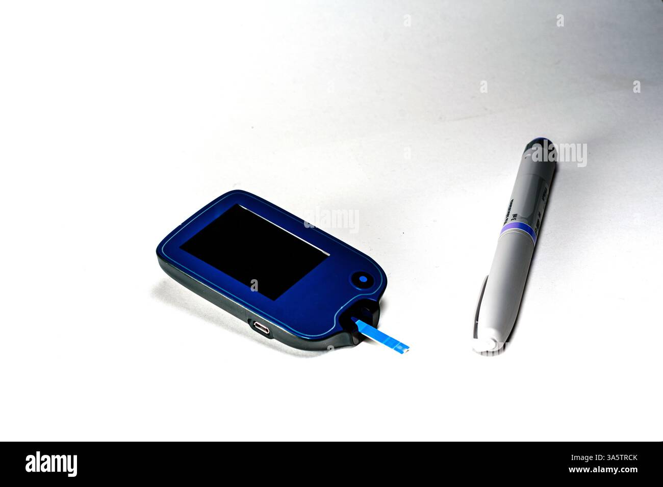 Glucose meter, insulin pen and test strip showing diabetes management ...