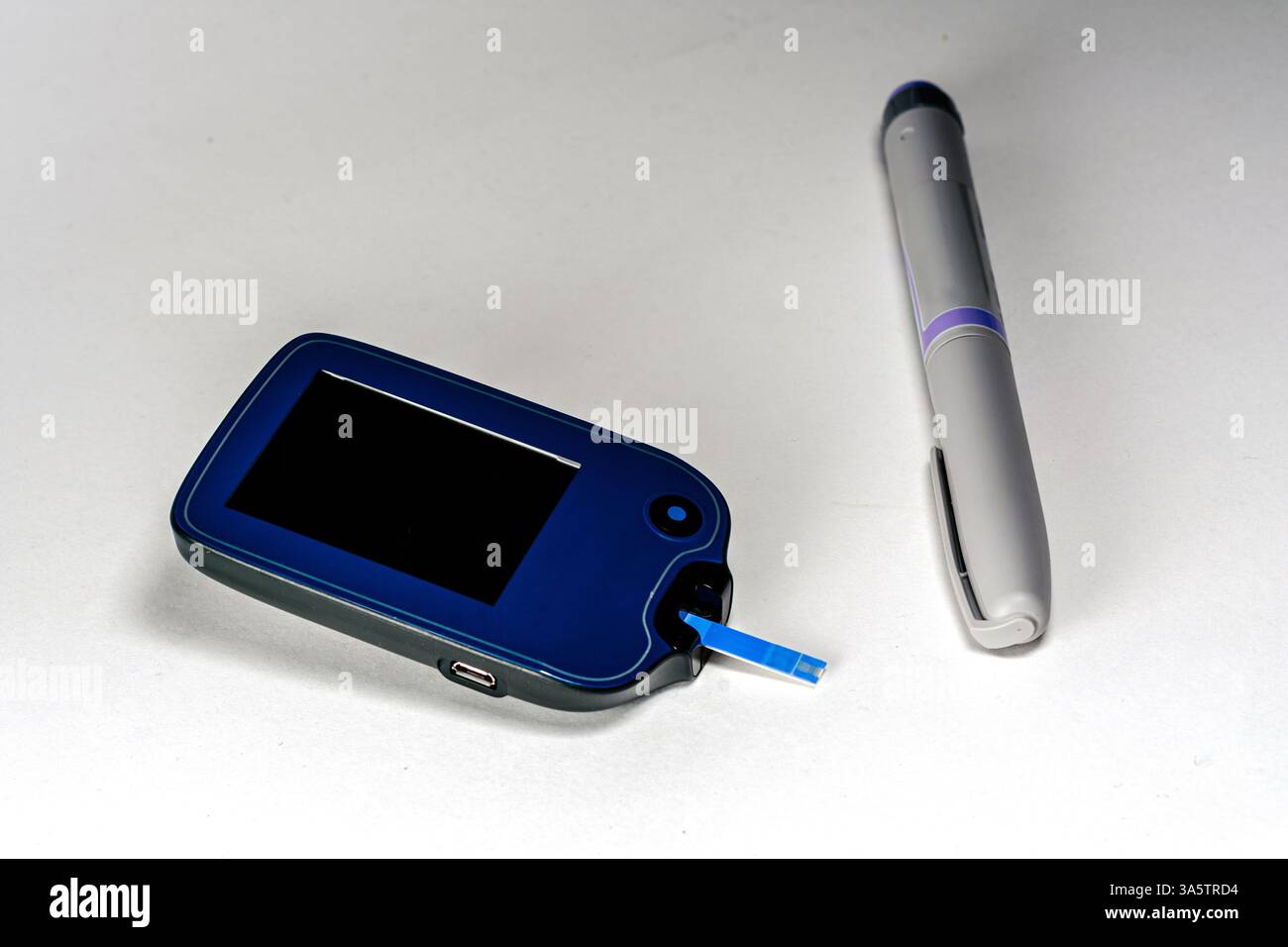 Glucose meter and insulin pen showing concept of diabetes management ...