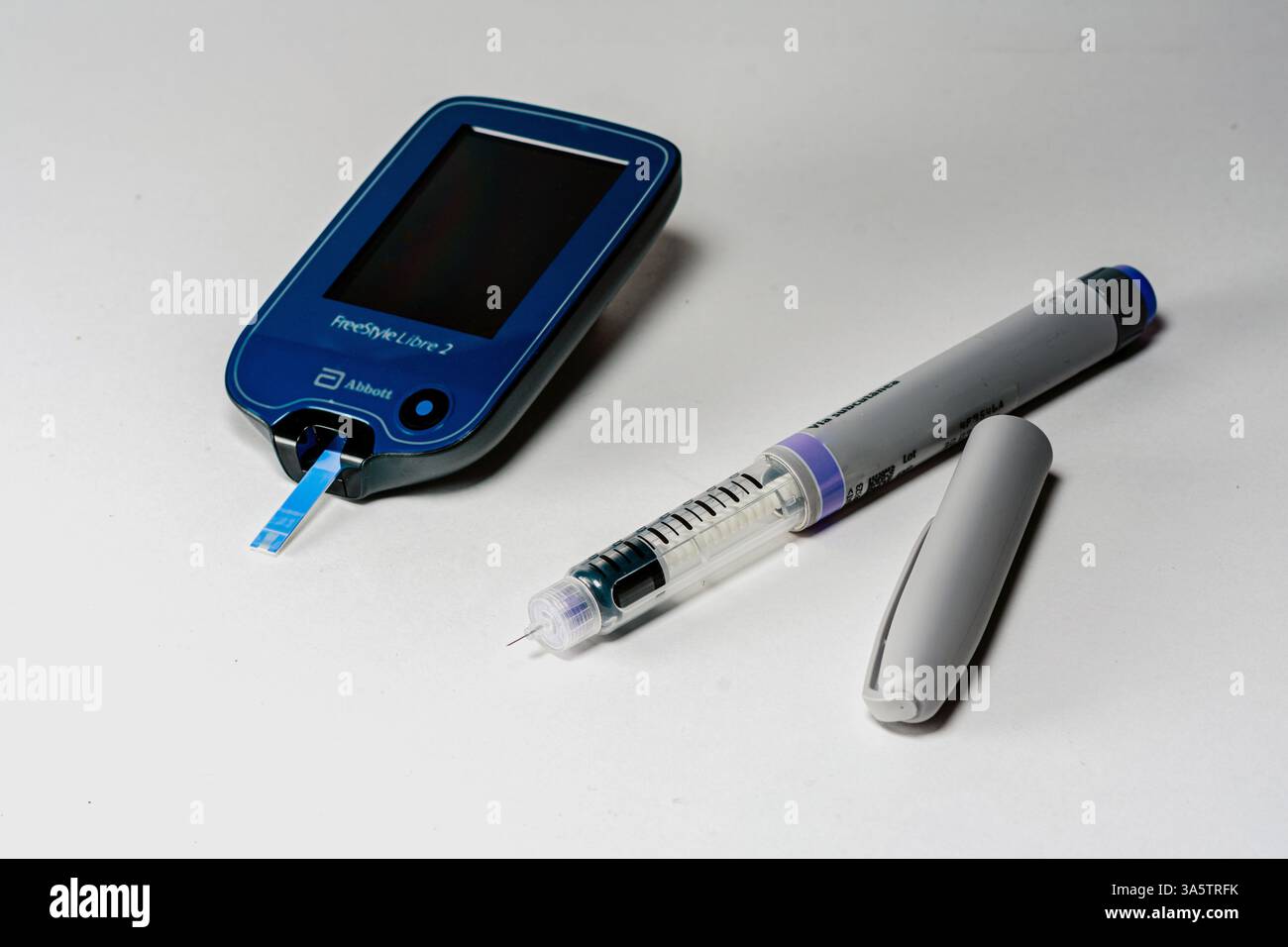 Glucose meter and insulin pen showing diabetes management tools Stock ...