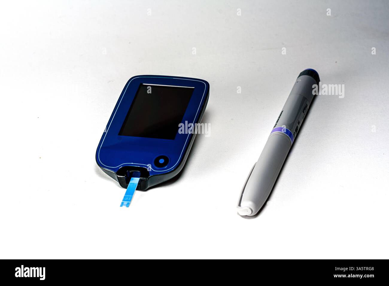 Glucose meter and insulin pen showing diabetes management tools Stock ...