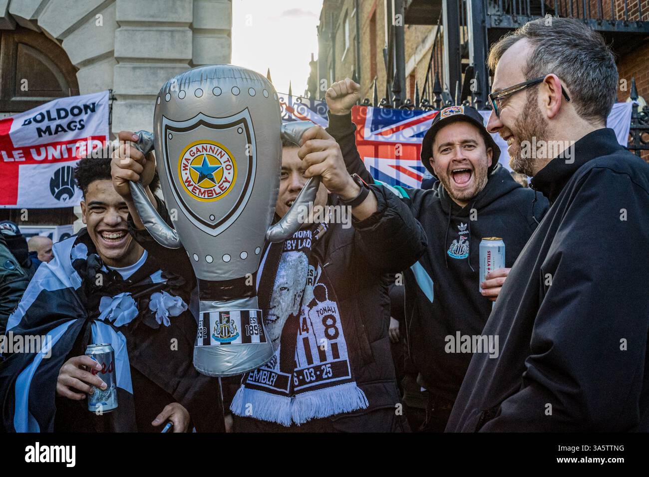 A group of supporters hold aloft an inflatable trophy. On the afternoon ...