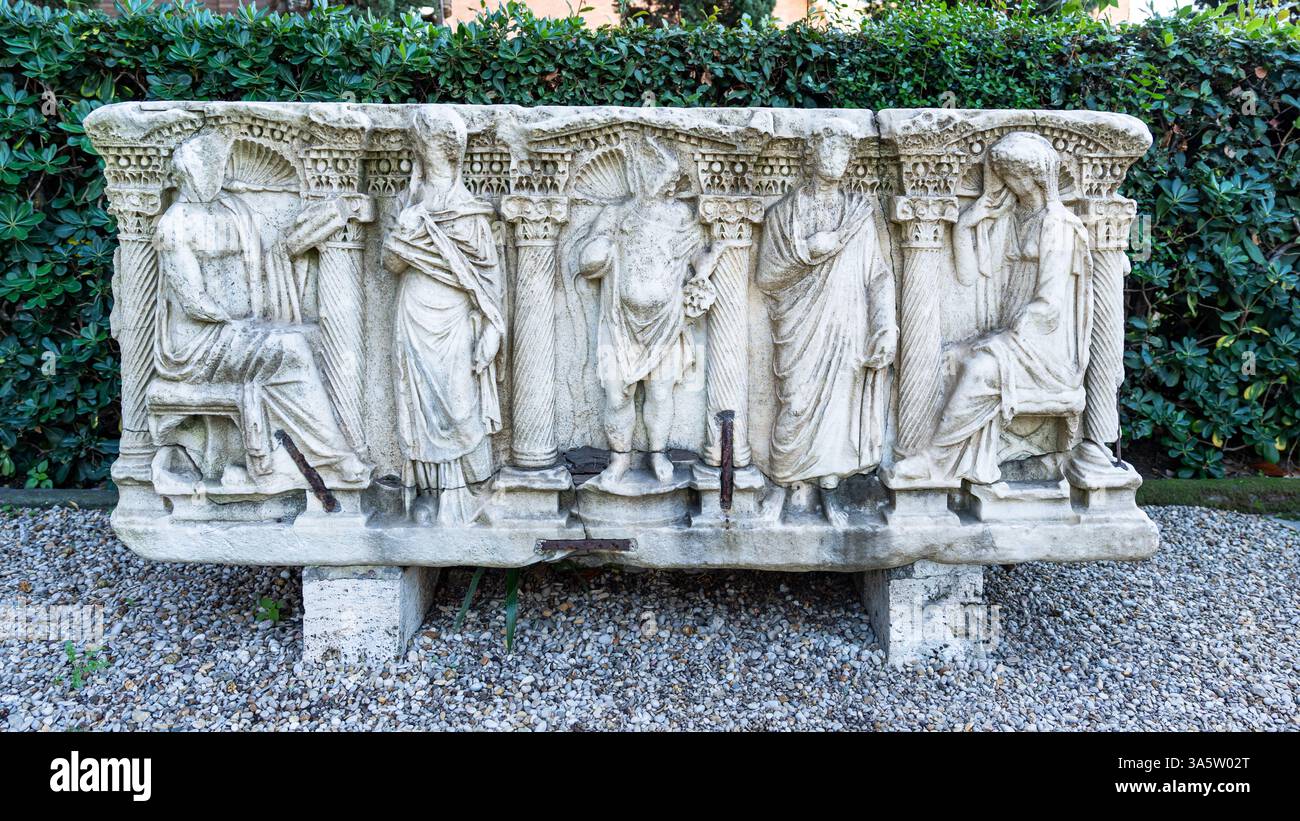 Ruins of ancient sarcophagus in marble decorated with carved sculptures of a group of people ...