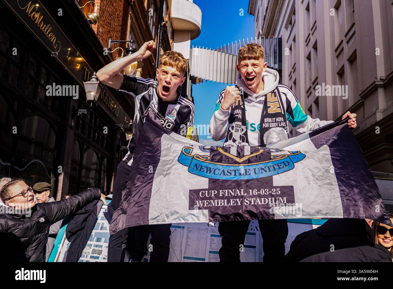 Holding a Newcastle United flag, two supporters gesture and cheer. On ...