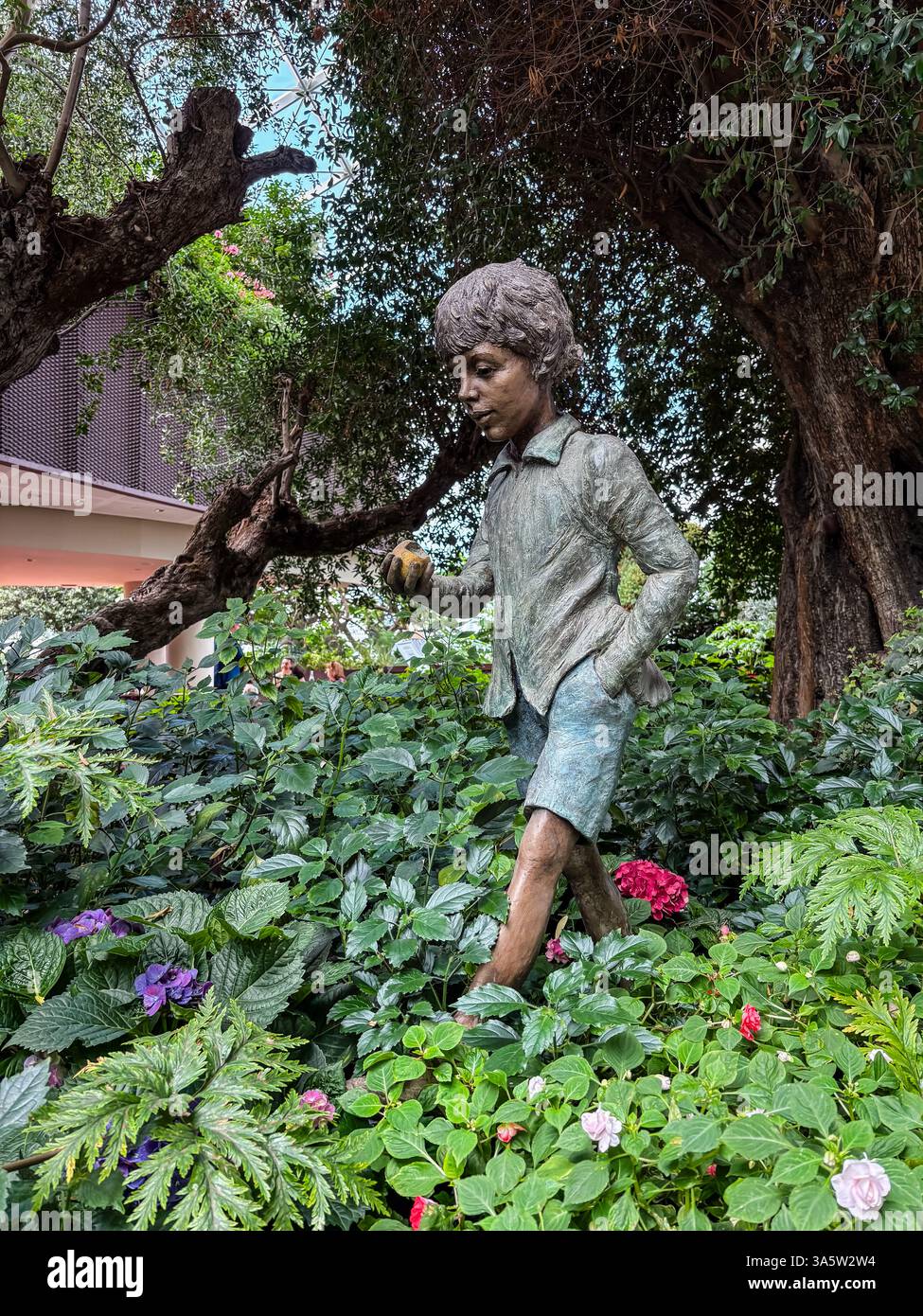 Flower Dome boy with apple sculpture. Bronze statue of a boy walking ...
