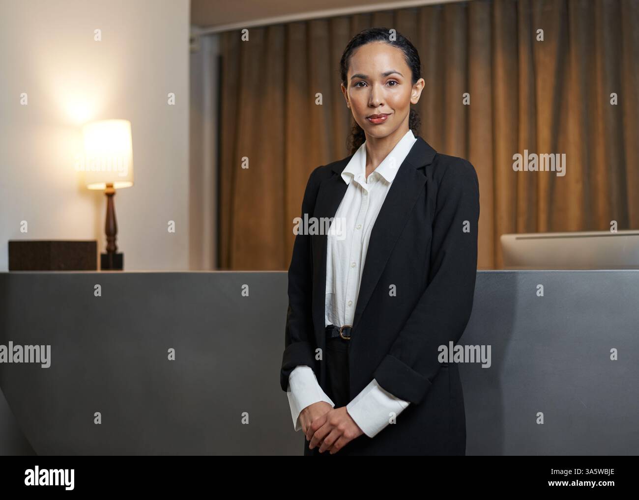 Professional Hotel Receptionist stands at Front Desk Welcoming ...