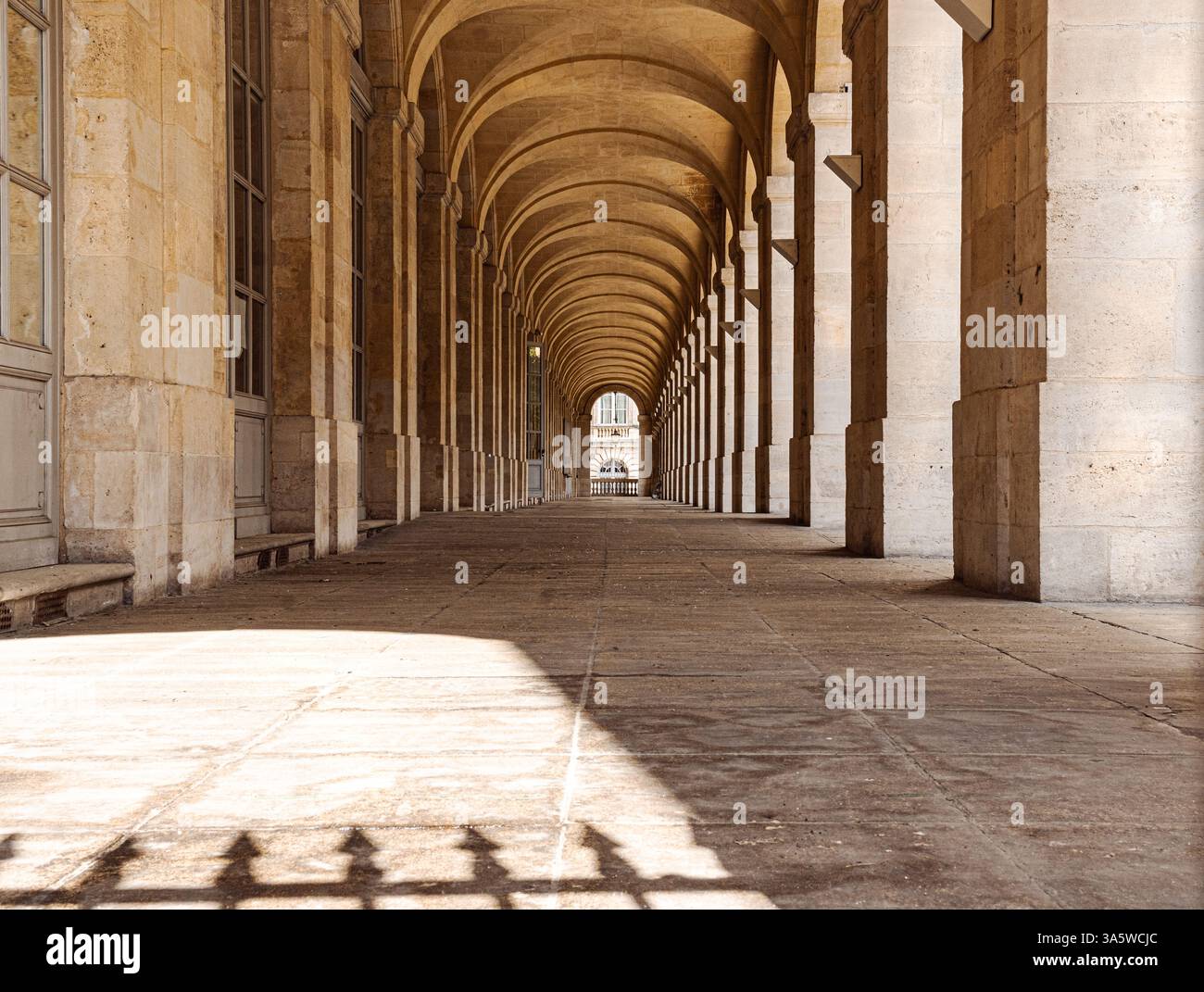 A long stone arcade with repeating arches in a historic building ...