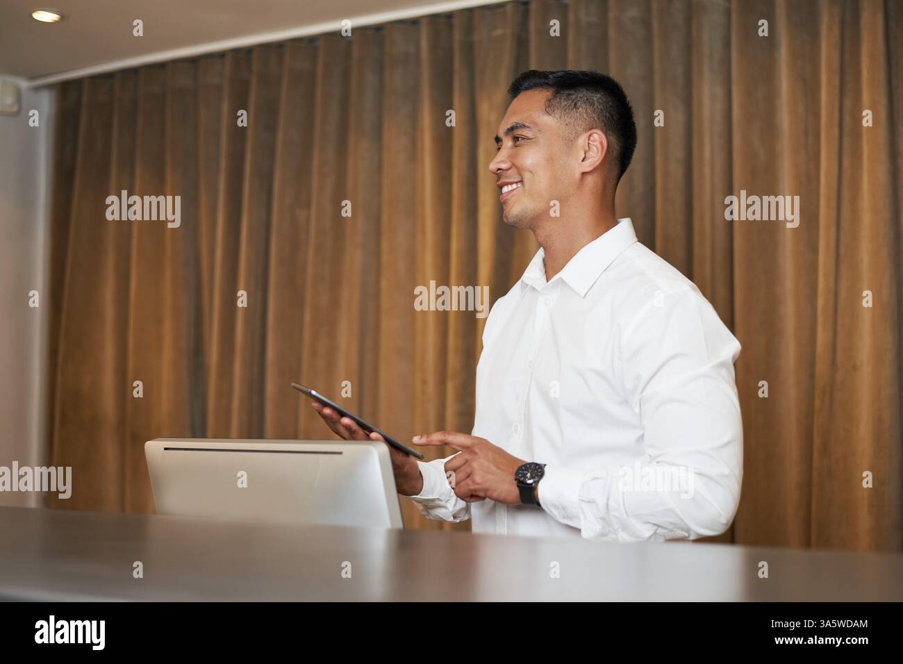 Professional Receptionist Smiling While Using a Tablet at the Hotel ...