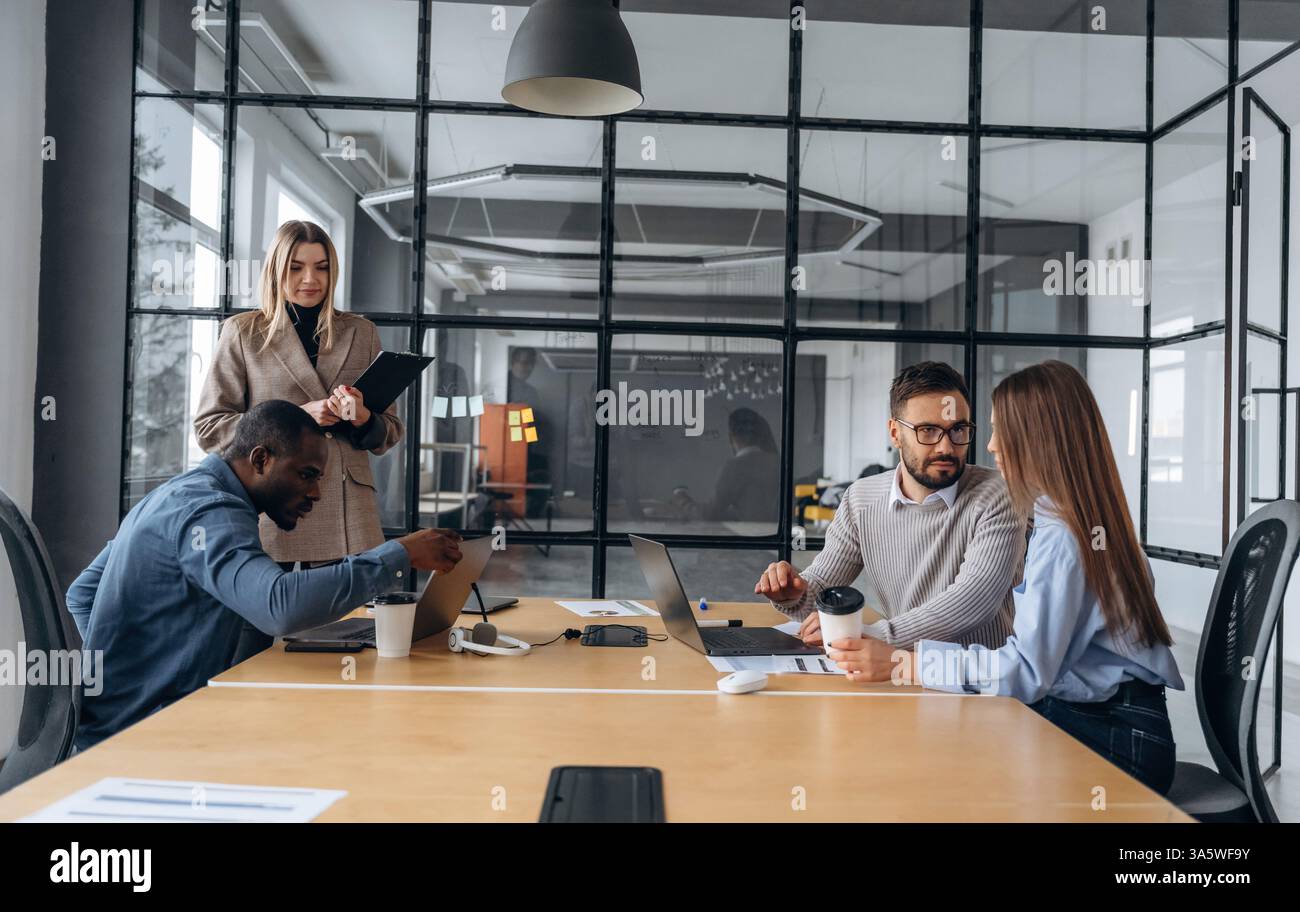 Calm, sitting by the table. Professional workers are in the modern ...