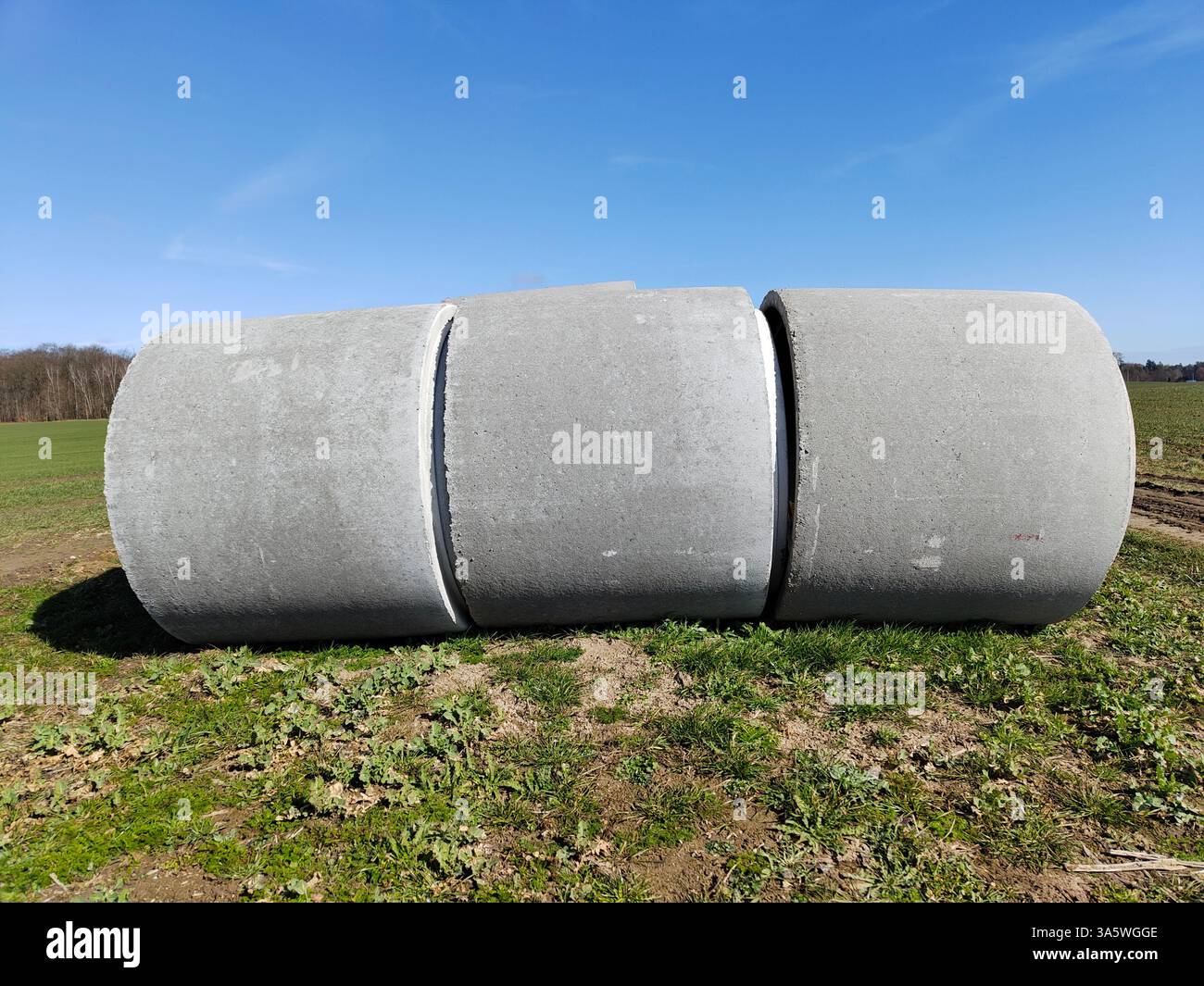 Large concrete pipes on grassy field under clear blue sky Stock Photo ...