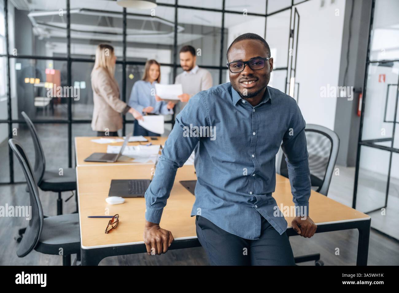 Positive black man. Professional workers are in the modern office ...