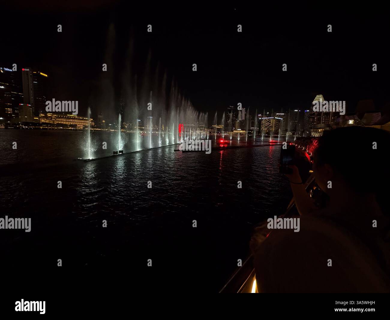 Spectra light show at Marina Bay Sands in Singapore at night. A woman ...