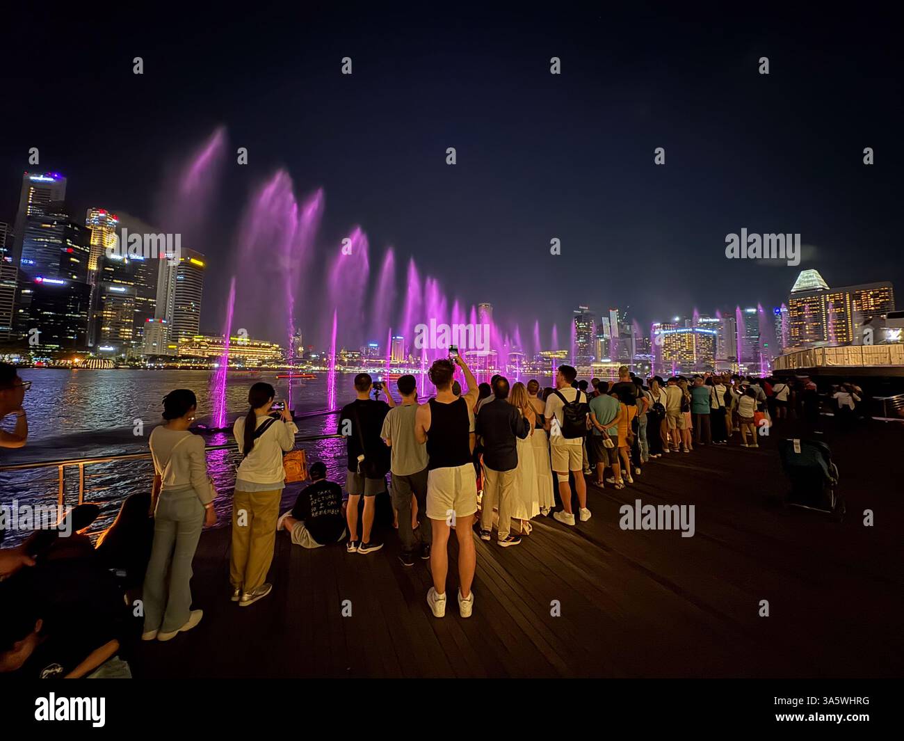 The Spectra light and water show in Singapore. A crowd of people watch ...