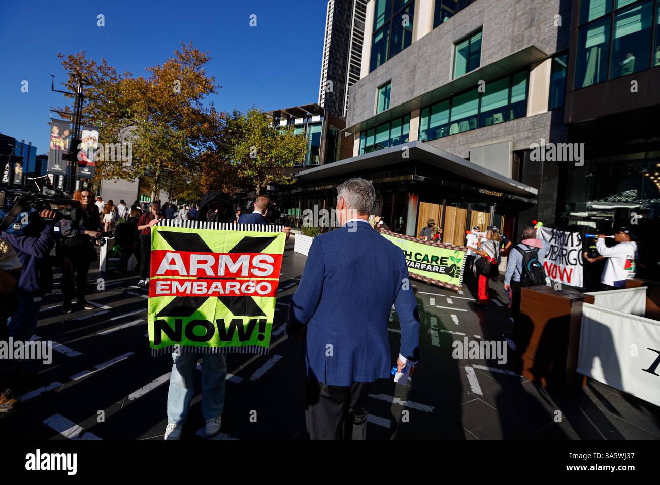 A protester holds a sign during a demonstration targeting a dinner at ...