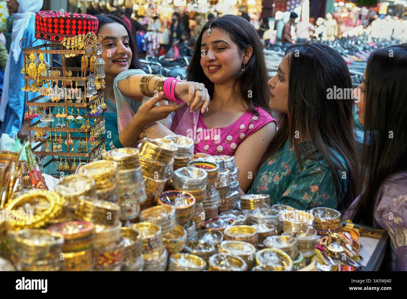 Girls look at traditional bangles and costume jewelry as they visit a ...