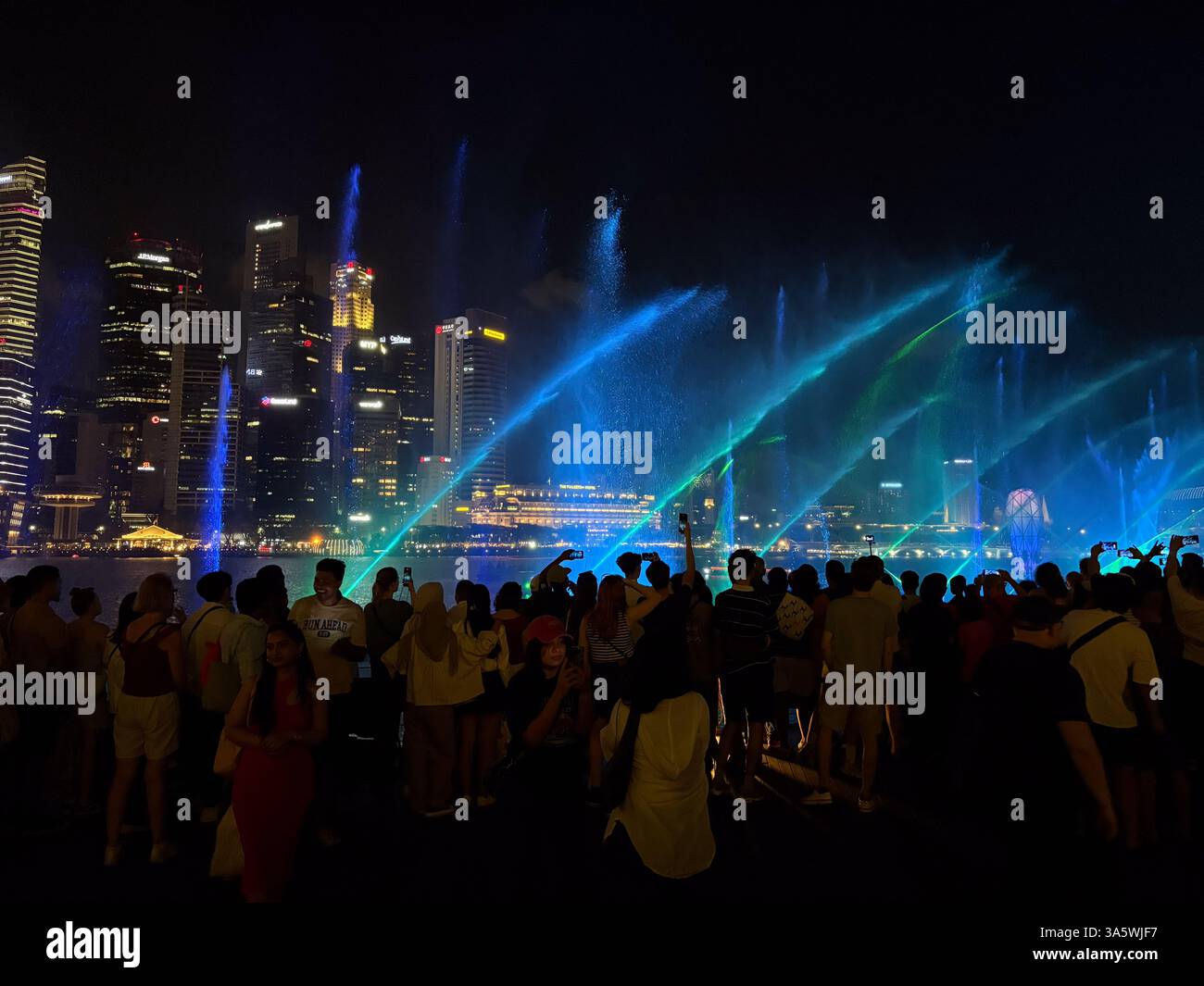 Spectra is a light and water show in Singapore, with crowds of people ...