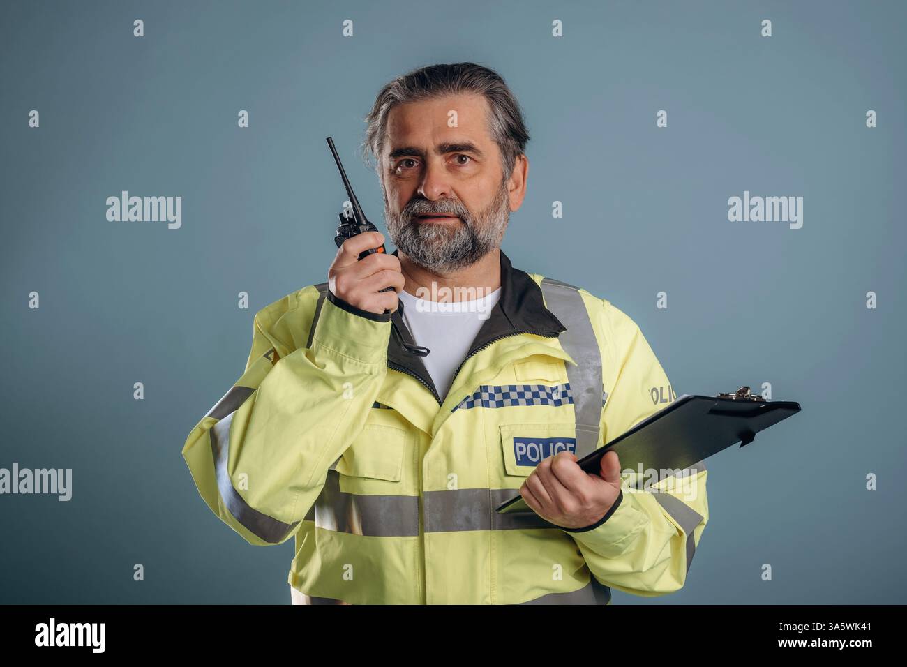 Talking into walkie talkie, police officer. Senior man is standing in ...