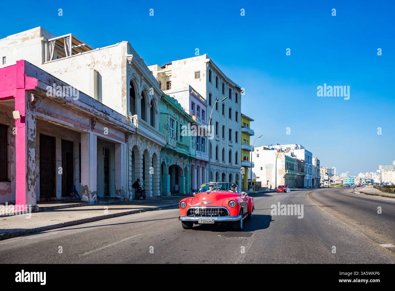 Tourists in vintage car cruising around the historic water front of ...