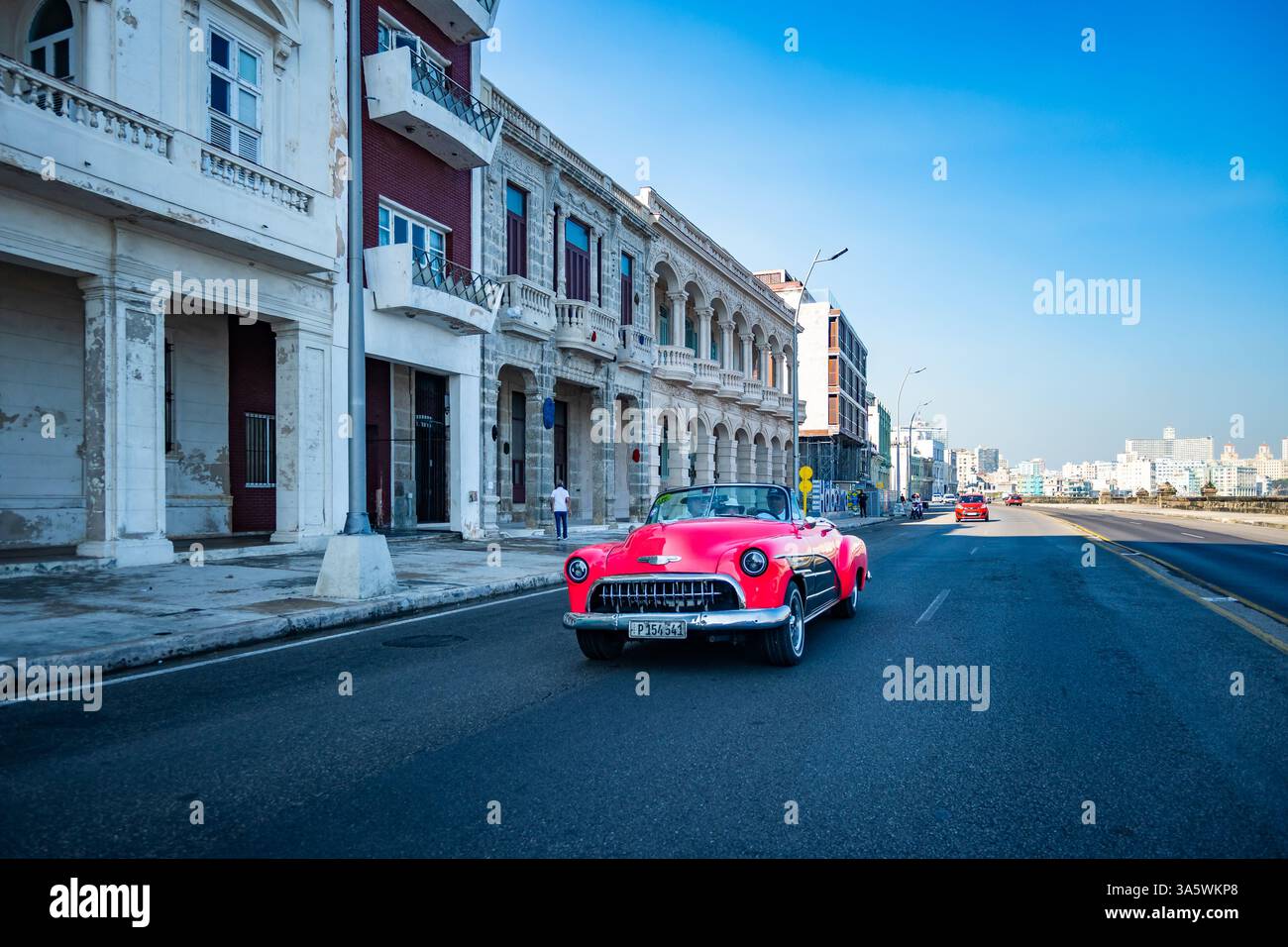 Tourists in vintage car cruising around the historic water front of ...