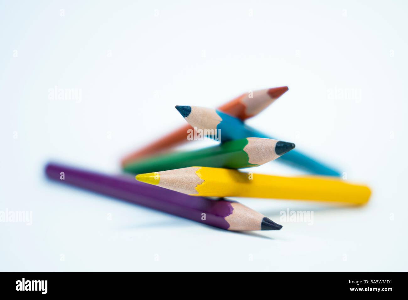 A clean and minimalist photo of pencil colours arranged on a white ...