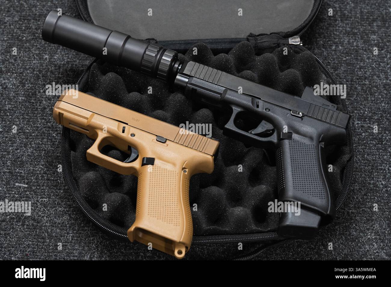Tactical firearms, two pistols, sand colored and black with silencer ...