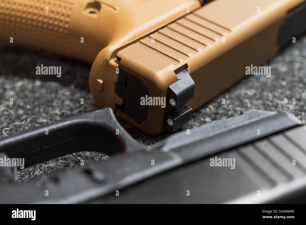 Close-up: rear sight of a sand-colored pistol in focus, contrast with ...