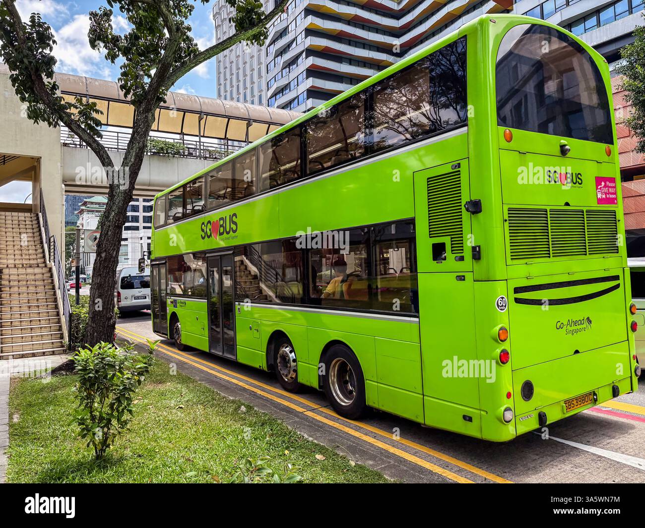 The Go-Ahead Singapore bus is shown, a vibrant green double-decker public transportation vehicle ...