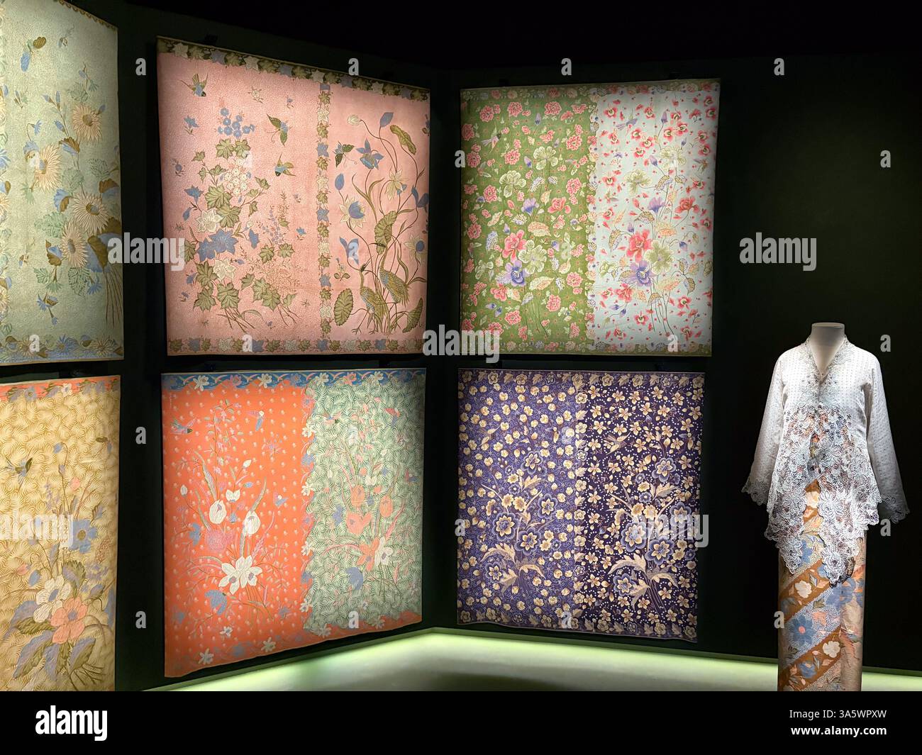 Display of batik textile prints and a traditional kebaya outfit on a ...
