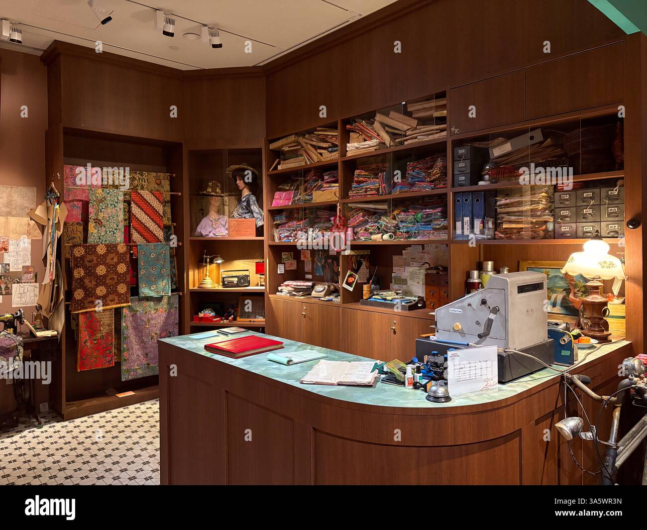A retro store display with old sewing machine and display of batik ...