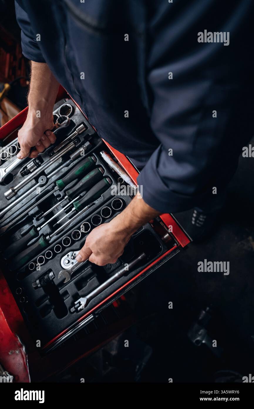 Choosing bunch from bunch of tools. Close up view of mechanic in car ...