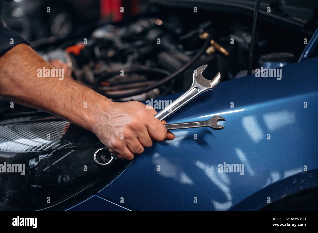 Blue automobile, working. Close up view of mechanic in car service ...