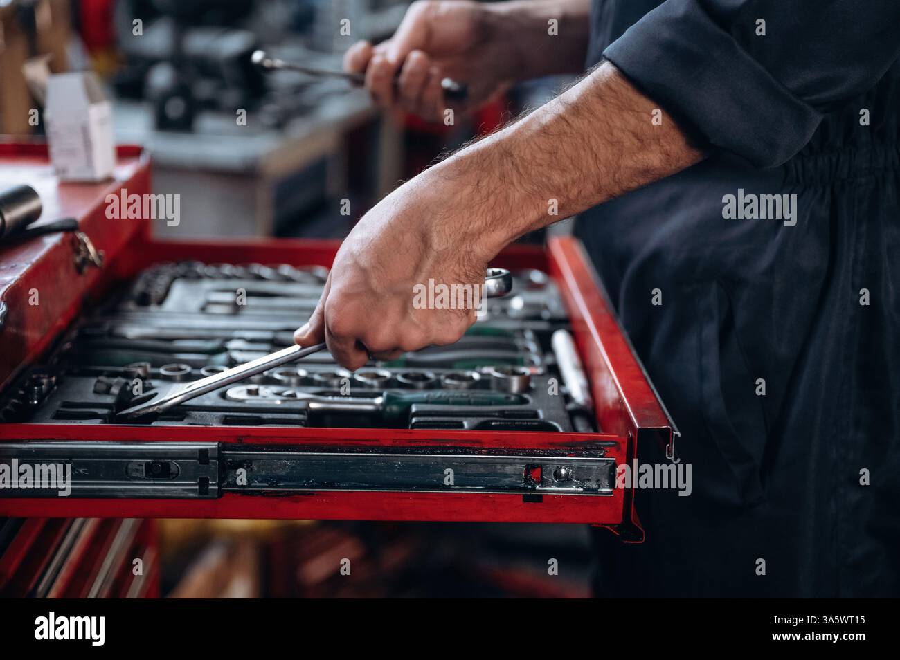 Choosing bunch from bunch of tools. Close up view of mechanic in car ...