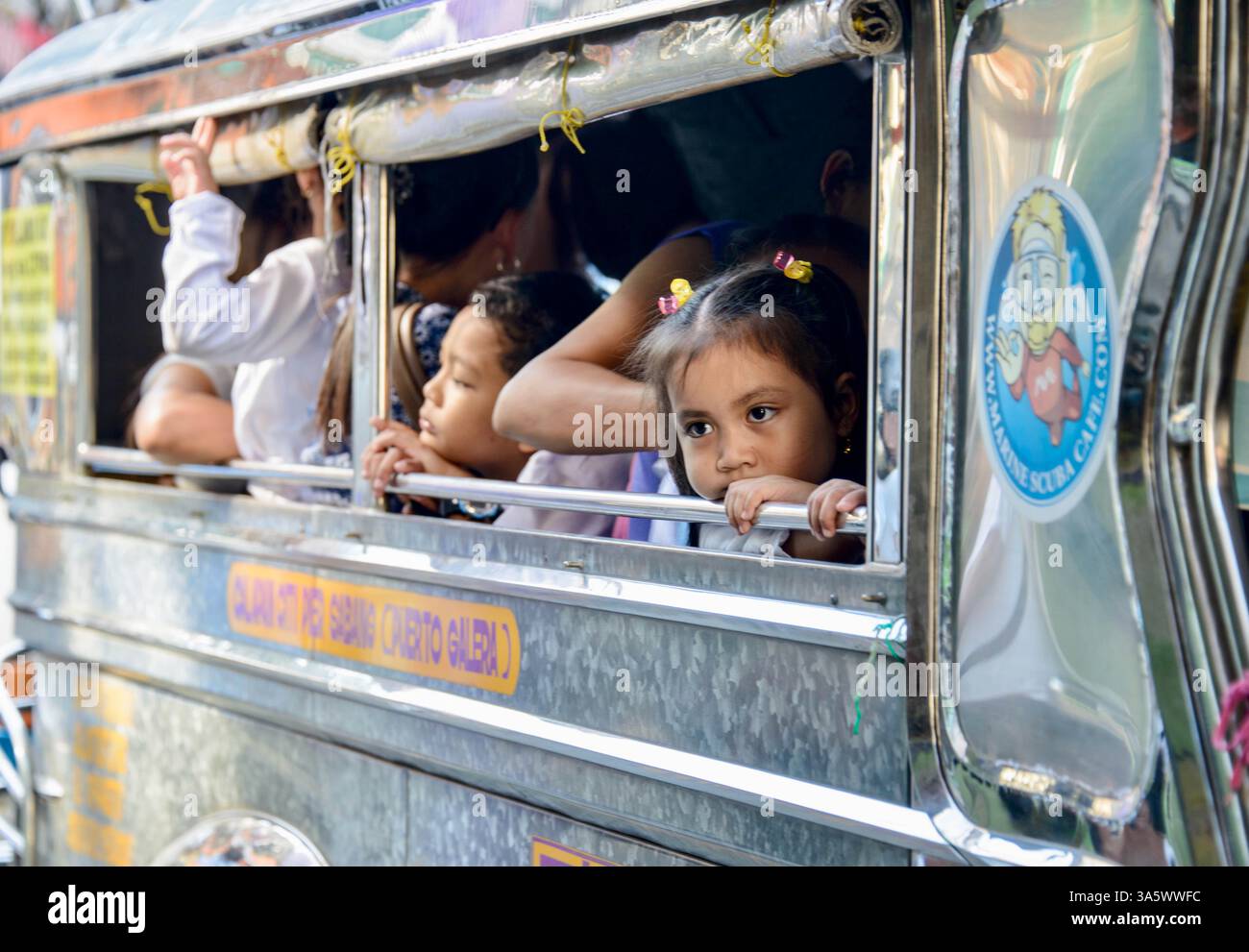 Children look out of the window of a jeepney in the Sabang area of ...